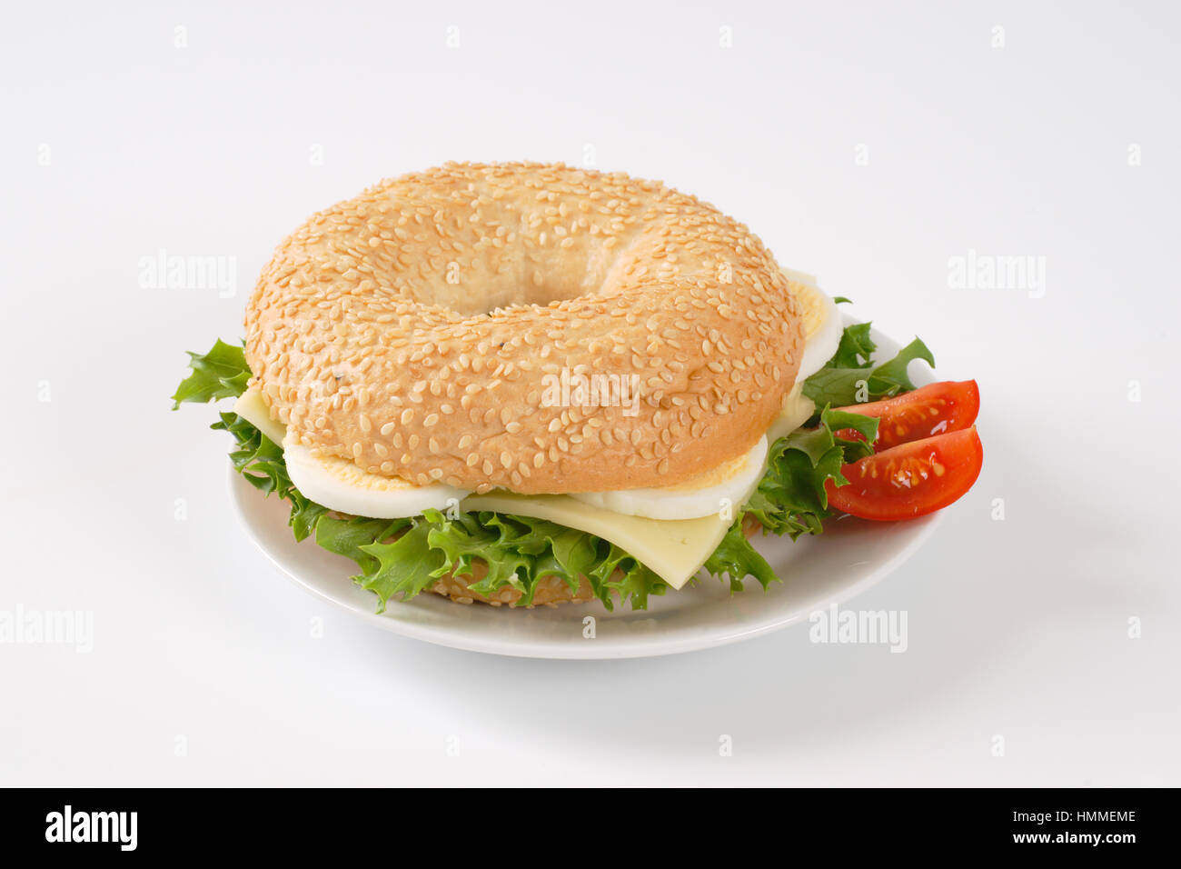 bagel sandwich with eggs and cheese on white plate Stock Photo - Alamy