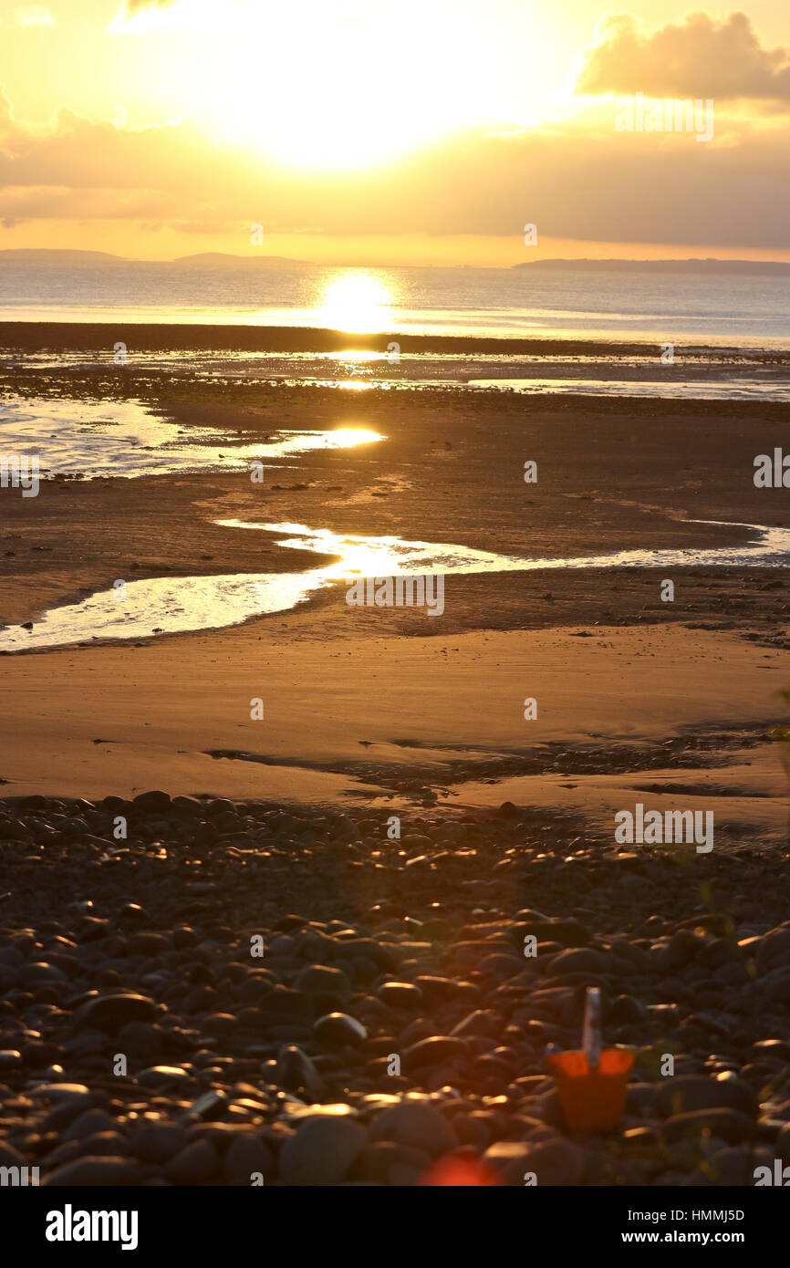 Sun rising over Dunster Beach Stock Photo - Alamy