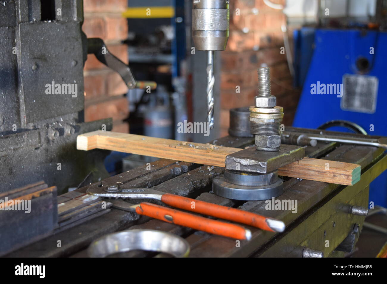 Engineering workbench with a drill machine and some tools and wrenches ...