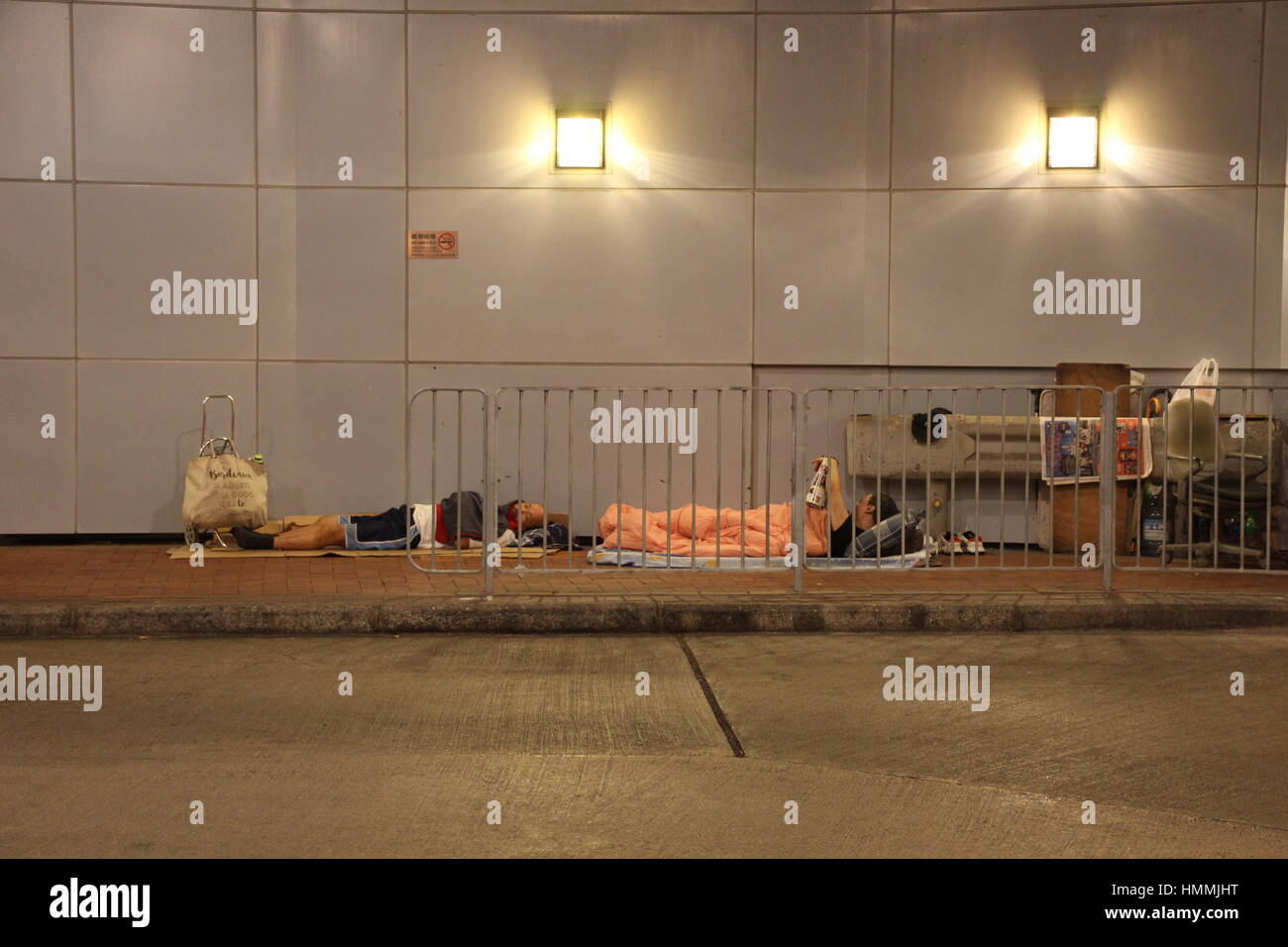 Homeless man at Tin Hau bus station reading a magazine Stock Photo - Alamy