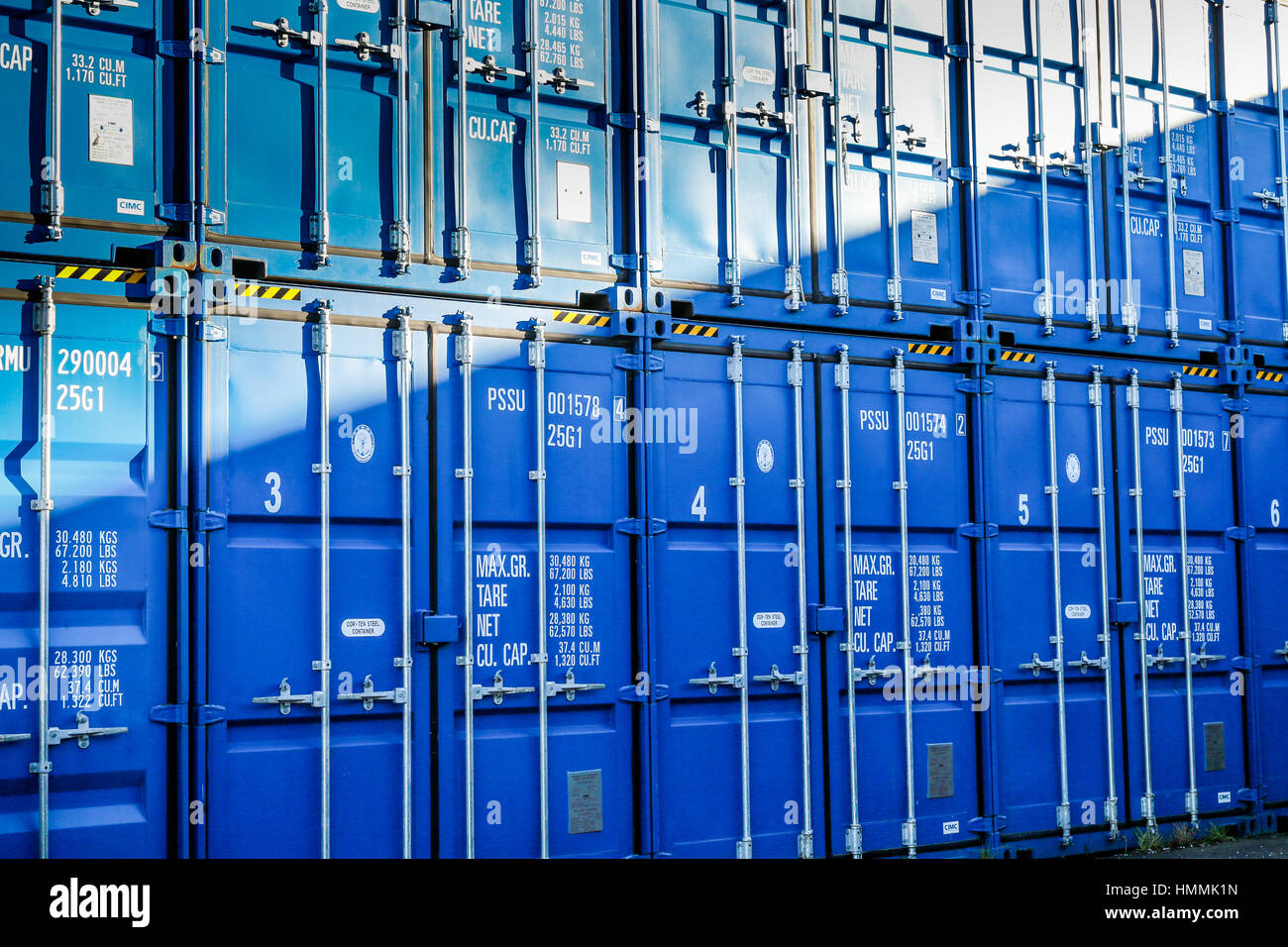 Blue shipping containers stacked waiting transport Stock Photo - Alamy