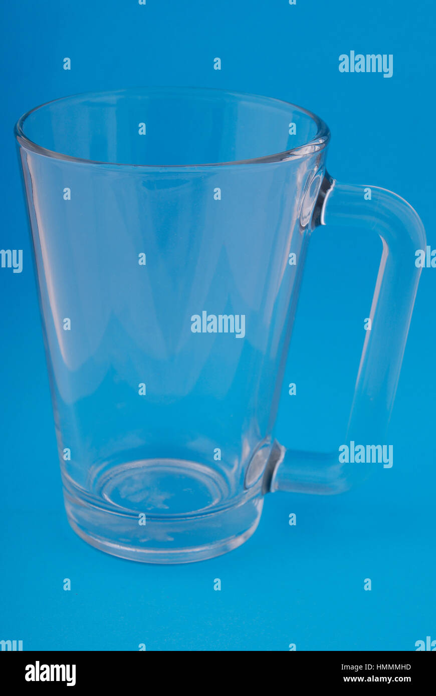 Glass mug. Blue background. Reflection, shadow and light Stock Photo ...