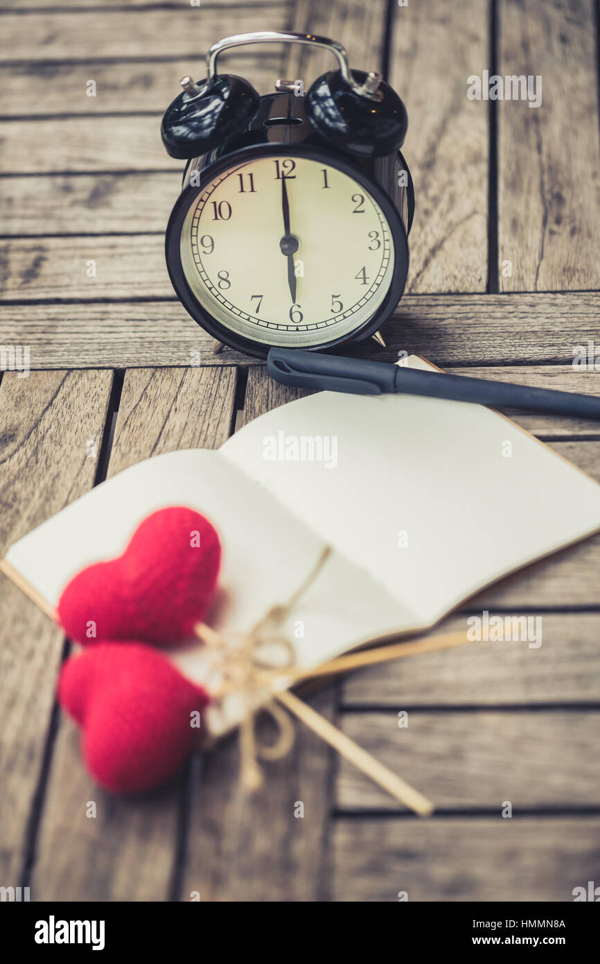 retro clock time at 6 o'clock with notebook or memo on wood table ...