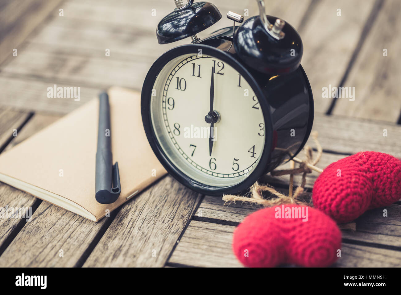 retro clock time at 6 o'clock with notebook or memo on wood table ...