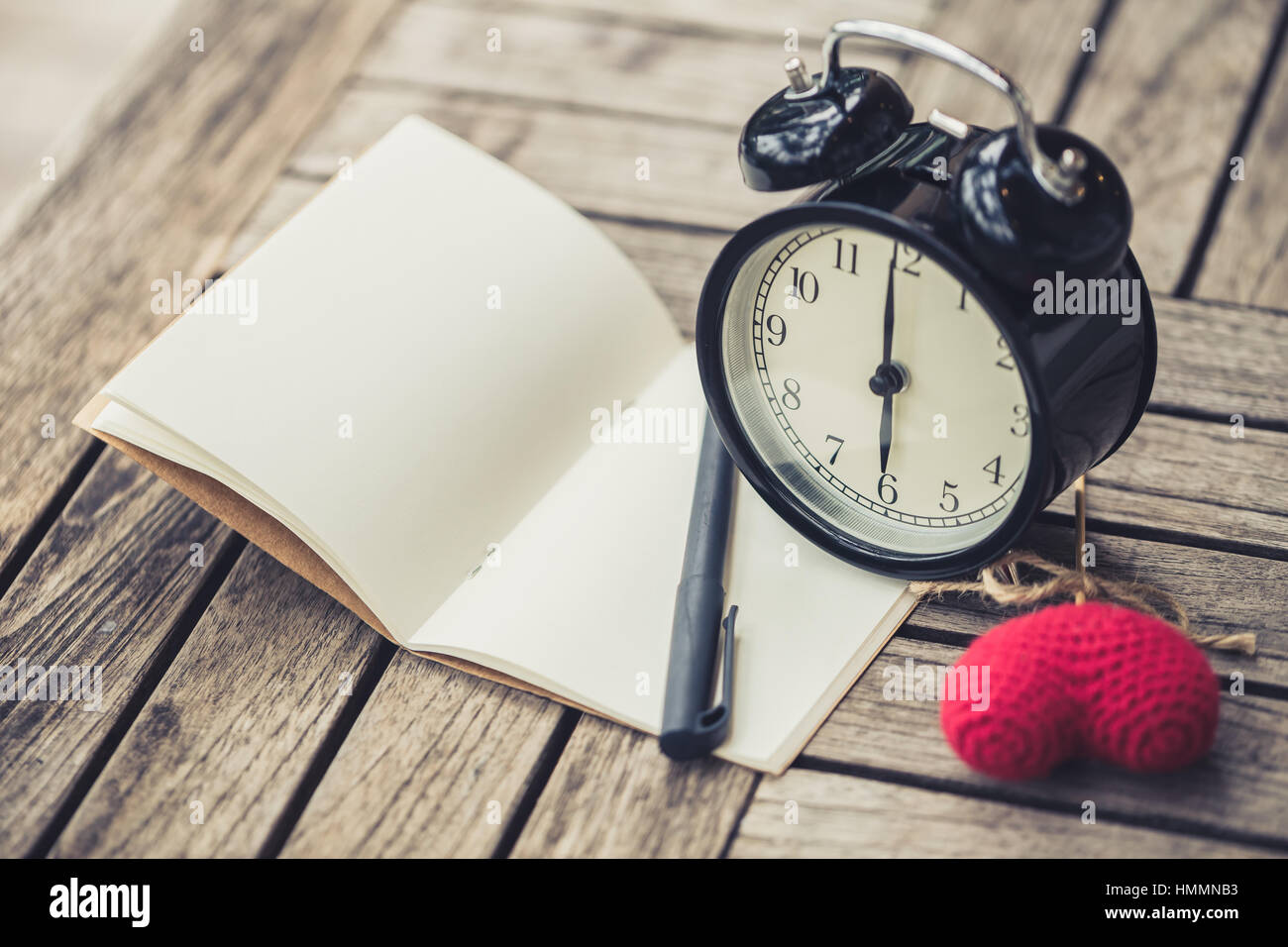 retro clock time at 6 o'clock with notebook or memo on wood table ...