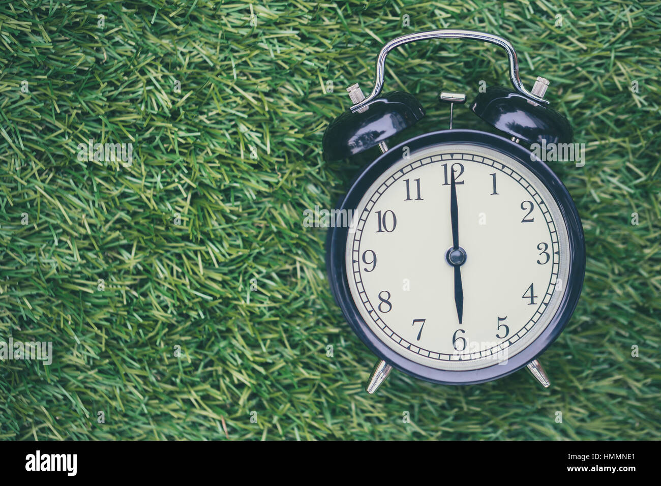 times retro clock lay on green grass nature face timed at 6 o'clock ...
