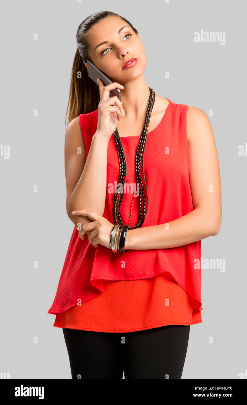 Beautiful woman making a phone call, isolated over gray background ...