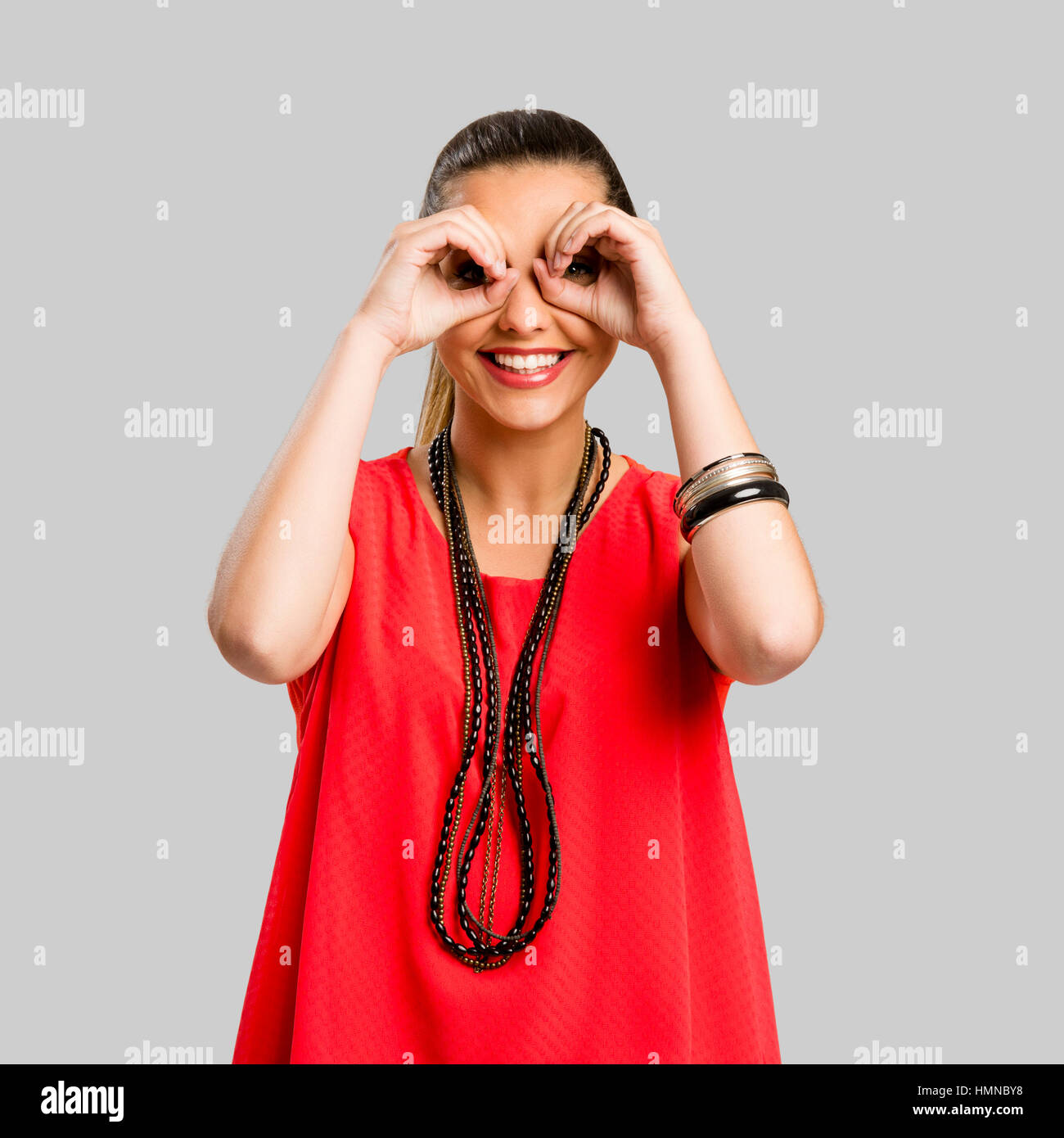Portrait of a beautiful woman using her hands to watch something Stock ...