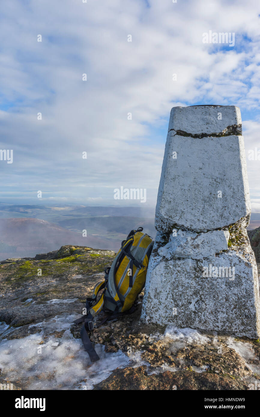 Trig point at the top of a mountain with a yellow rucksack leaning ...