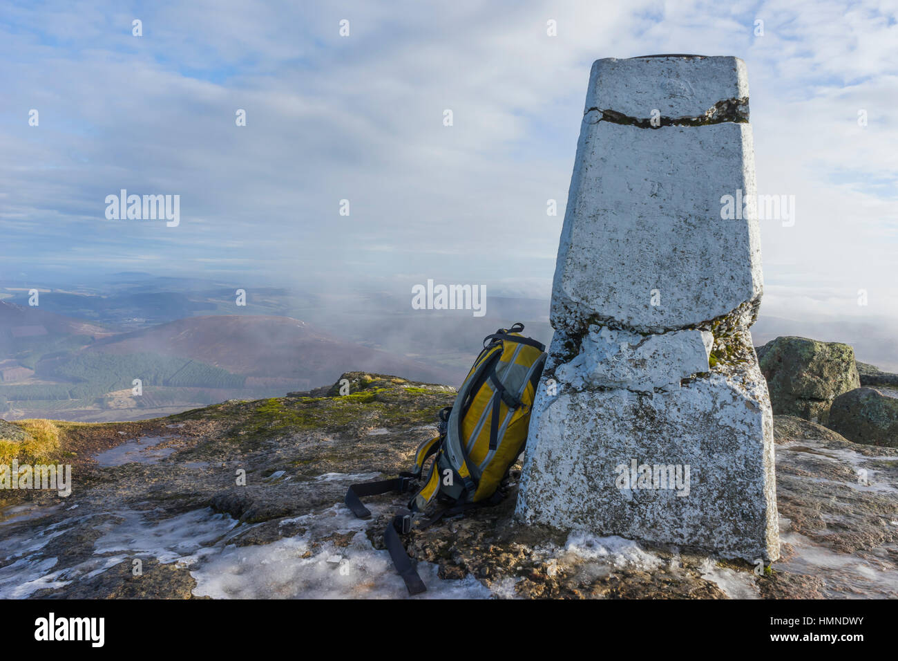 Trig point at the top of a mountain with a yellow rucksack leaning ...