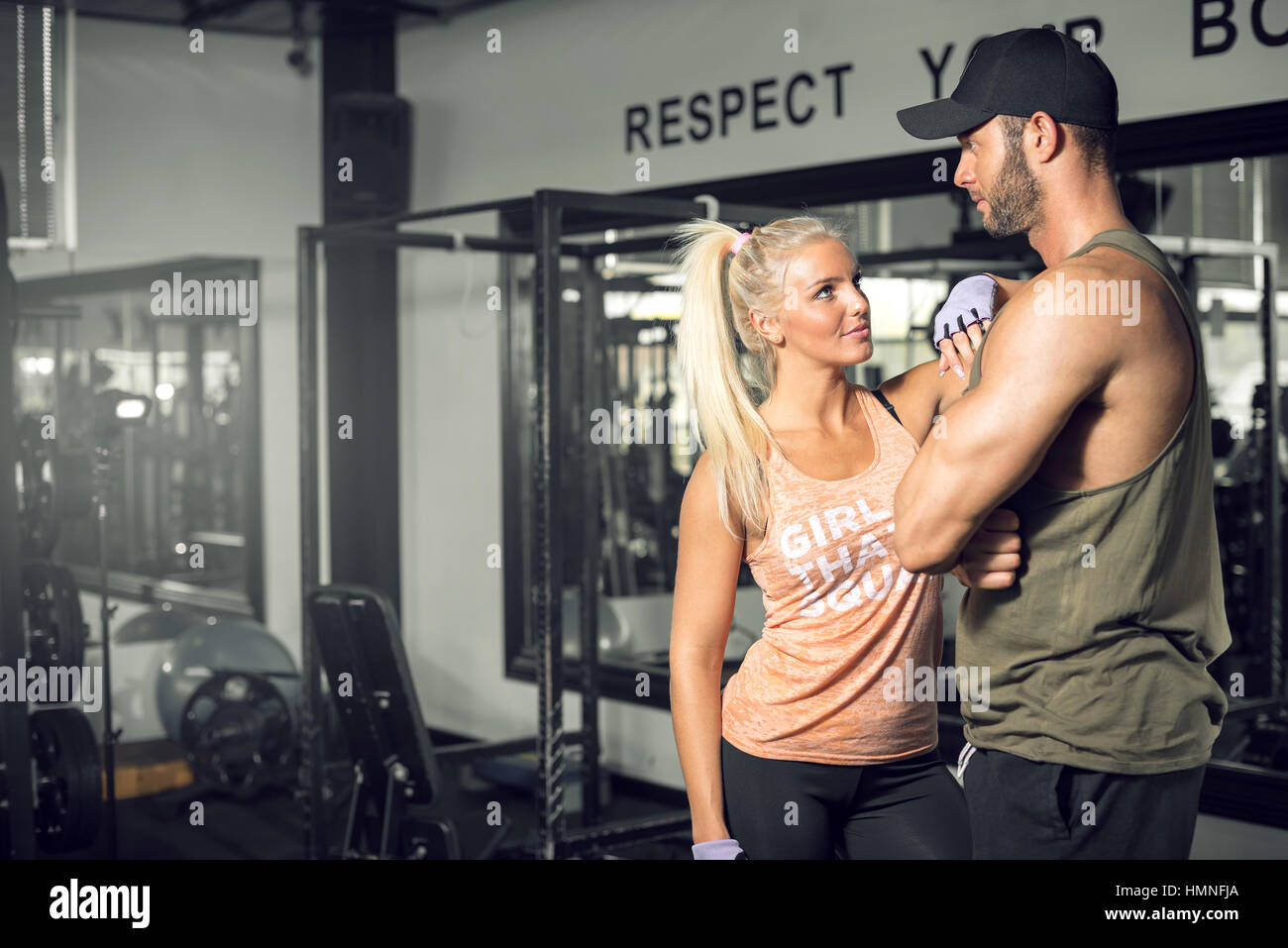 Young fitness couple in 20s standing together in modern fitness center ...