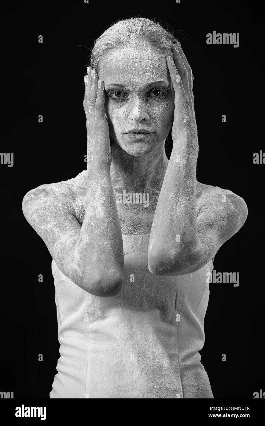 Art portrait of a Beautiful girl covered in white dust over black ...