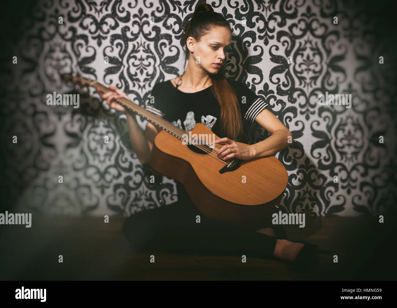 sad pretty girl with guitar sitting on a floor Stock Photo - Alamy