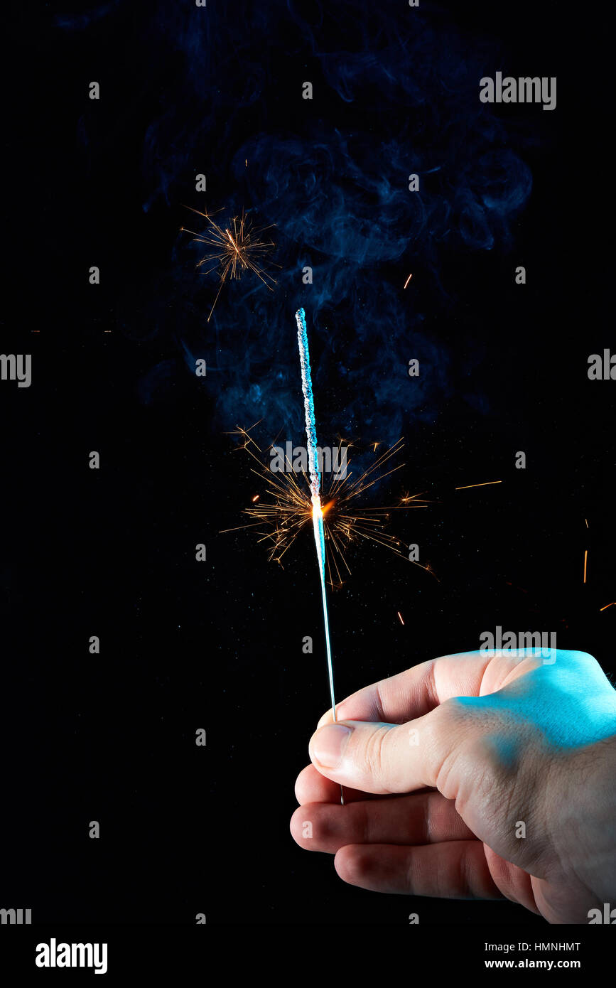 gold burning sparkles from sparkler in hand Stock Photo - Alamy
