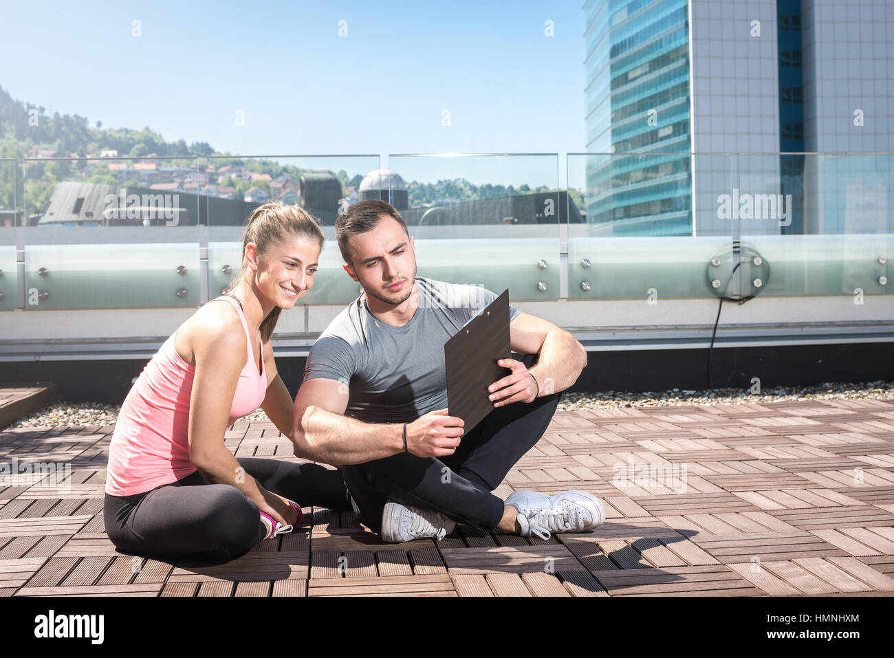 Young adult personal fitness trainer (coach) showing results and ...