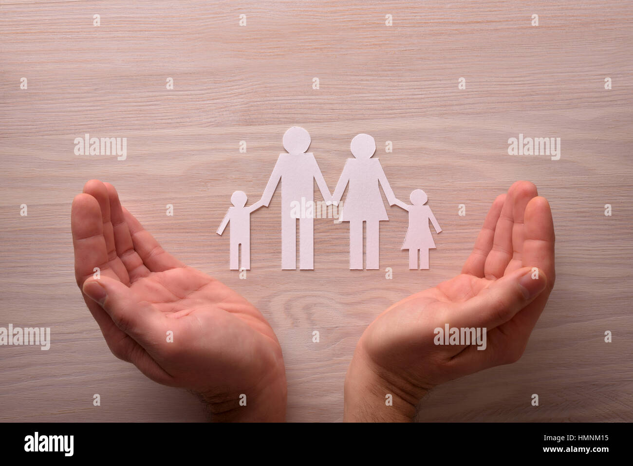 Concept of family protection with hands around a paper cutout family ...