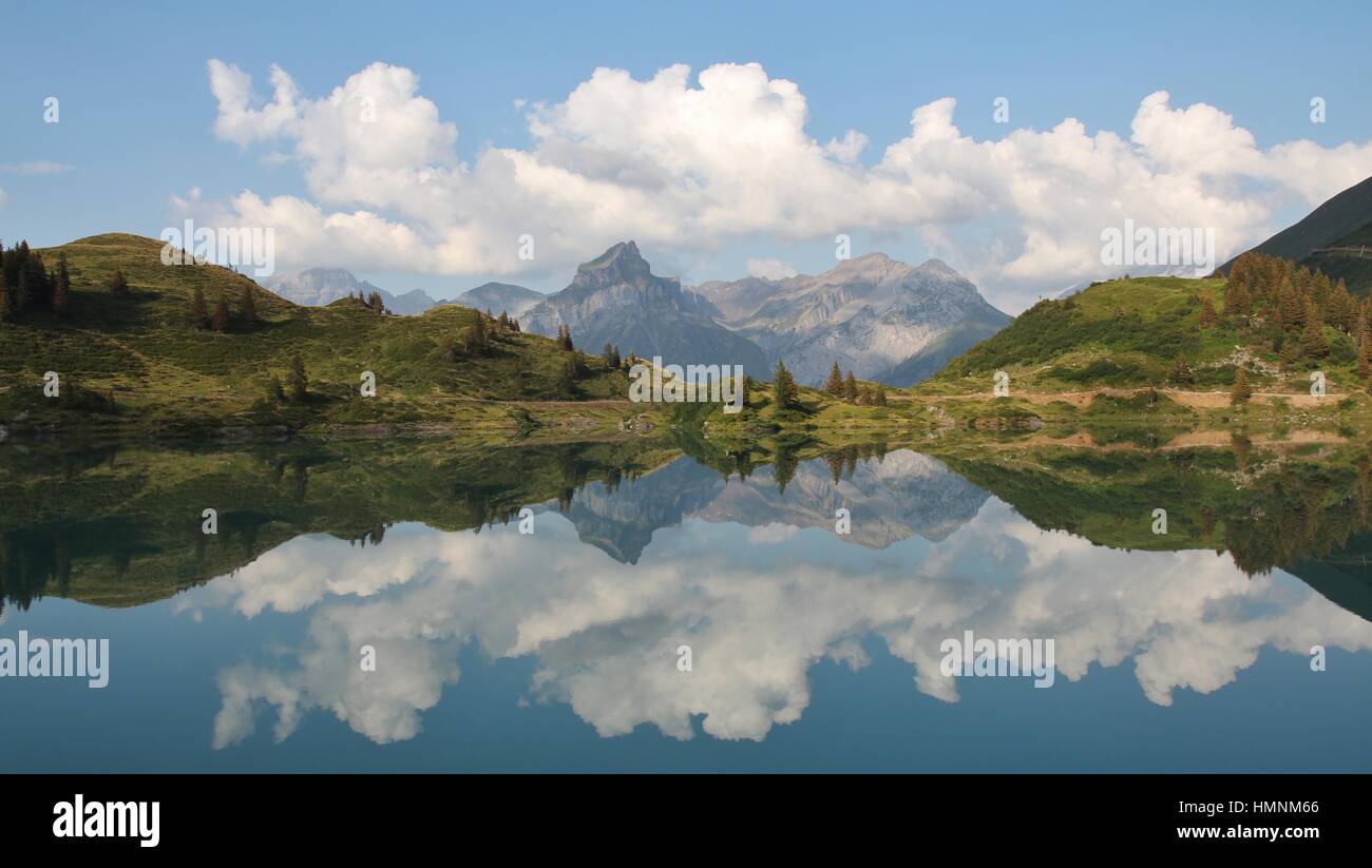 Summer clouds and mountains mirroring in lake Trubsee, Engelberg ...