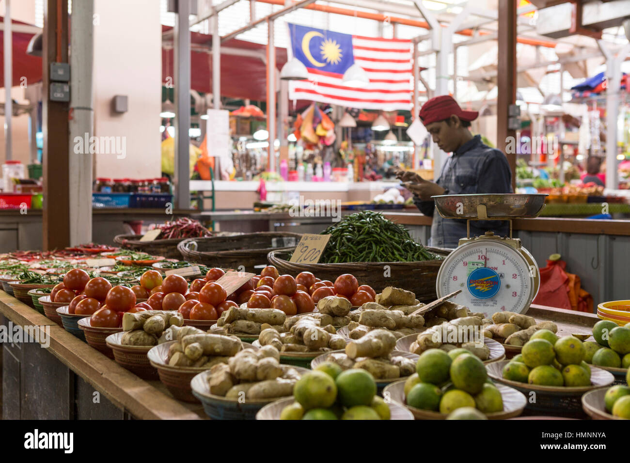 A vendor at a vegetable stall at a market in Chow Kit, Kuala Lumpur ...