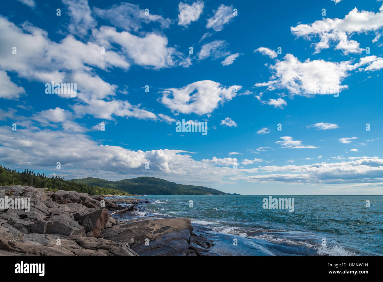 Rocky promontory in Superior Lake under blue cloudy sky. Canada Stock ...