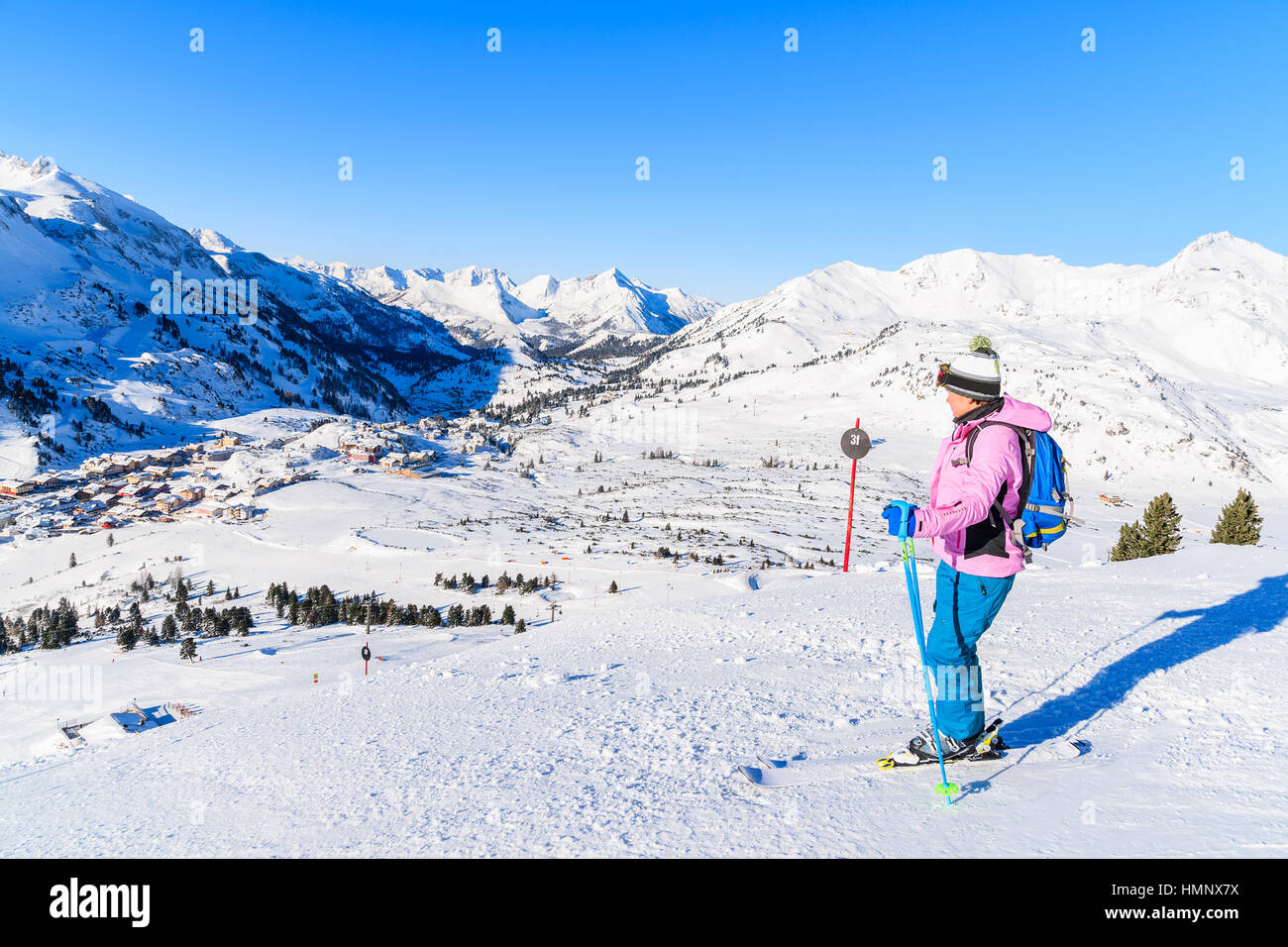 Young woman skier standing on ski slope in Obertauern winter mountain ...
