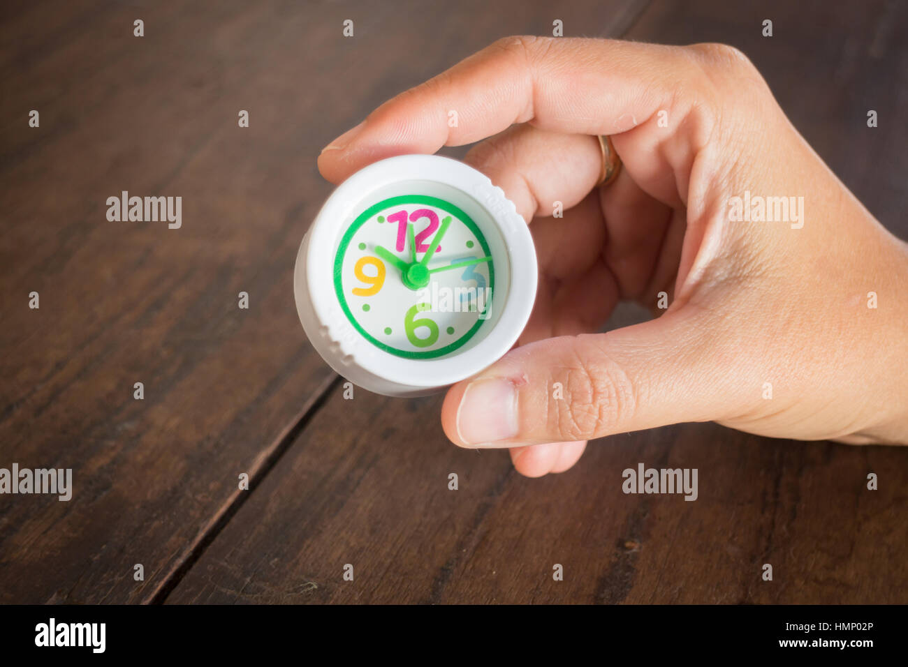 Mini white clock in hand, stock photo Stock Photo - Alamy