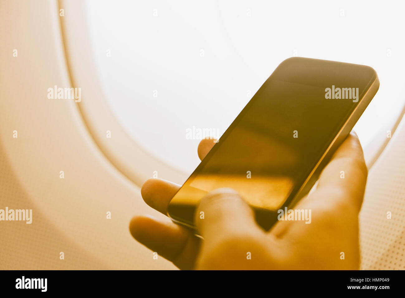 business man sits in airplane watching his cell phone Stock Photo - Alamy