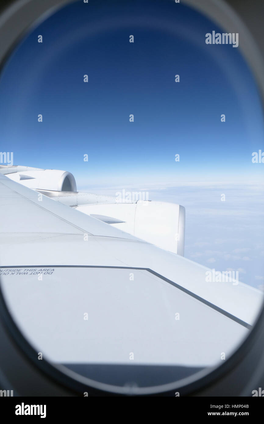 Looking through window aircraft during flight in wing with blue sky ...