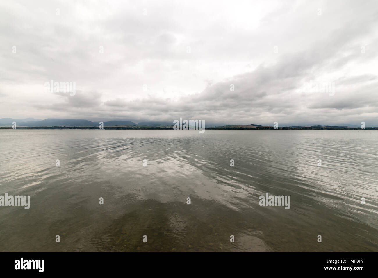 Reflections in the calm lake water with dramatic clouds Stock Photo - Alamy