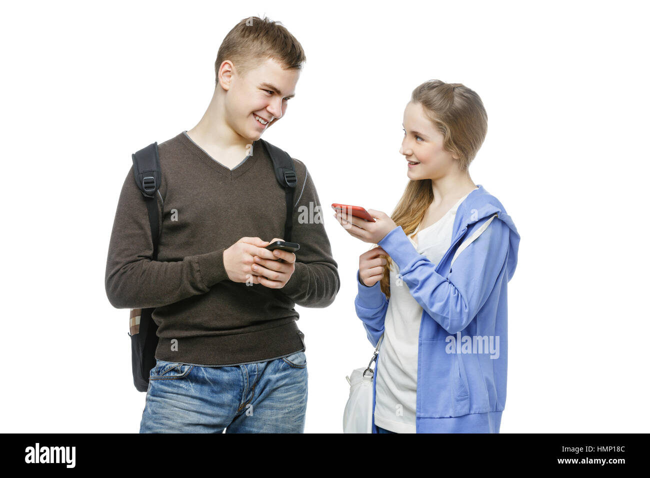 Teen boy and girl standing with mobile phones Stock Photo - Alamy