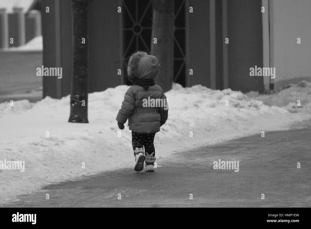 little girl made first steps on the slippery winter street, but don't ...