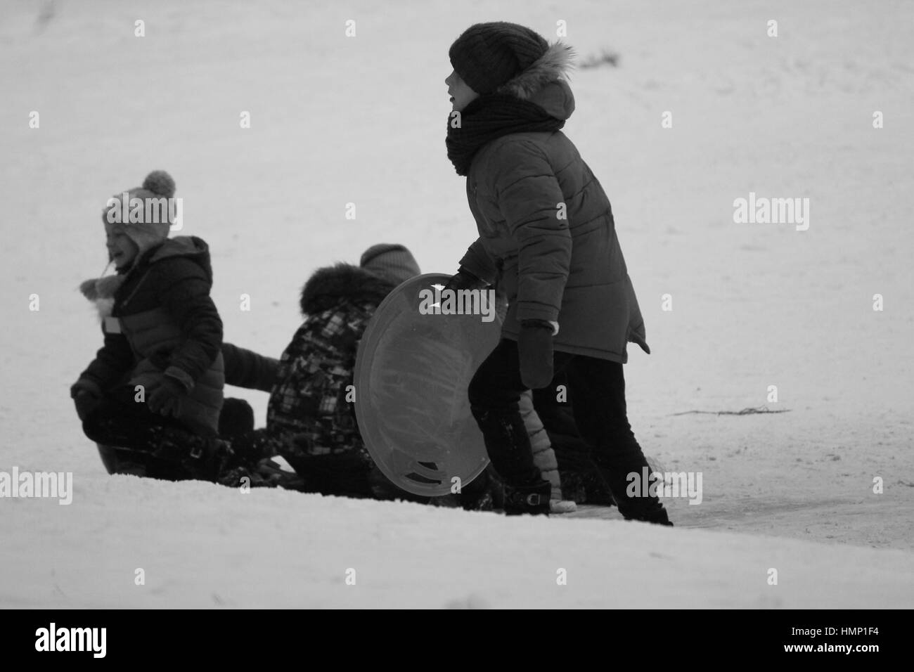 beautiful vivid school children play on slippery hill in cold winter ...
