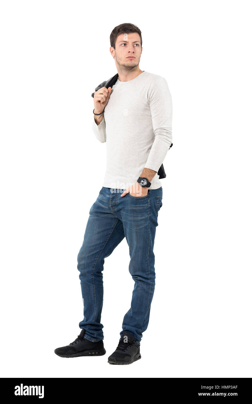 Young handsome man looking back over the shoulder with hand in pocket ...