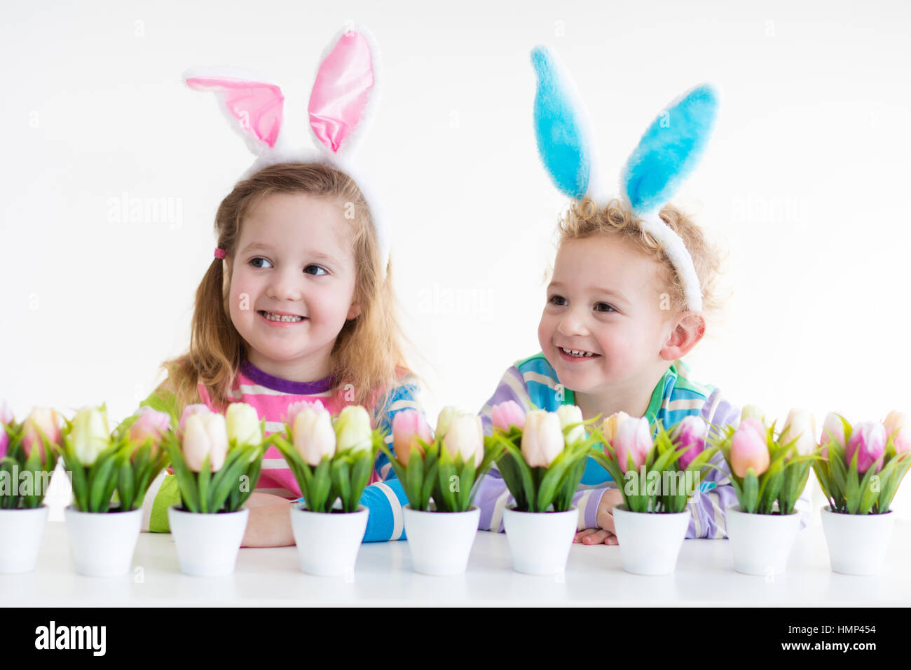 Happy children celebrate Easter at home. Boy and girl wearing bunny ...