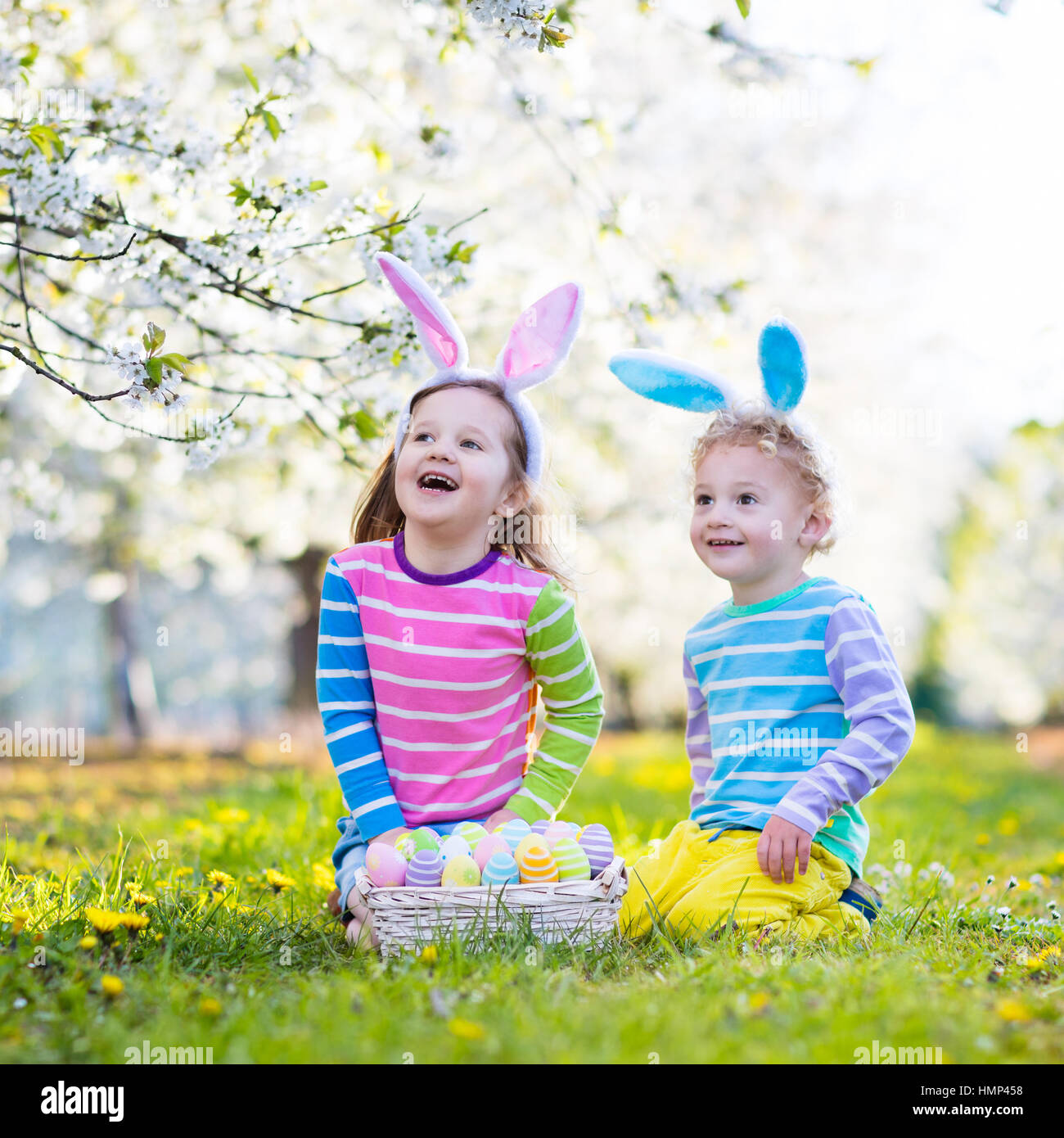 Kids on Easter egg hunt in blooming spring garden Stock Photo - Alamy