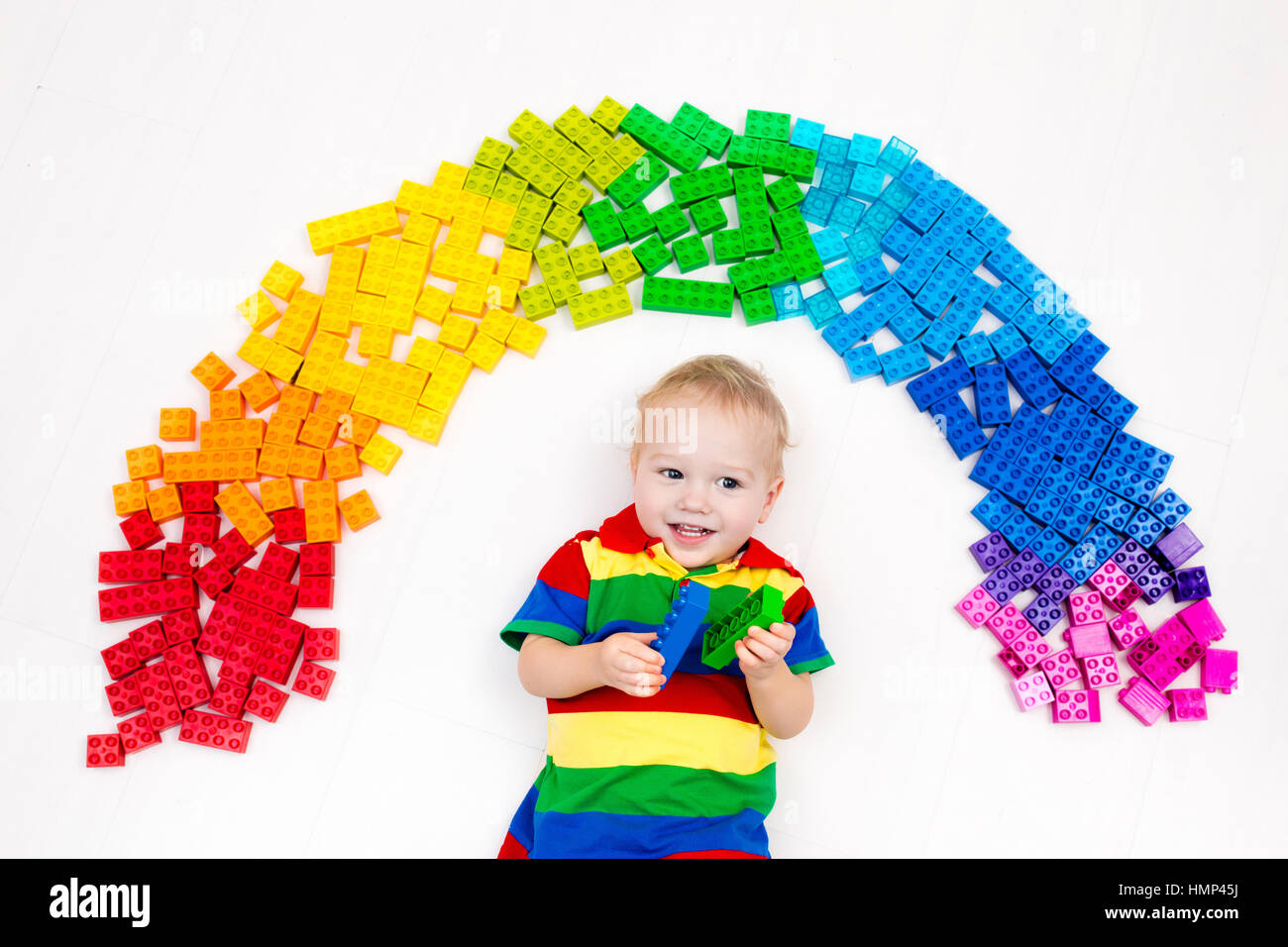 Funny little boy playing with colorful rainbow plastic blocks. Kids ...