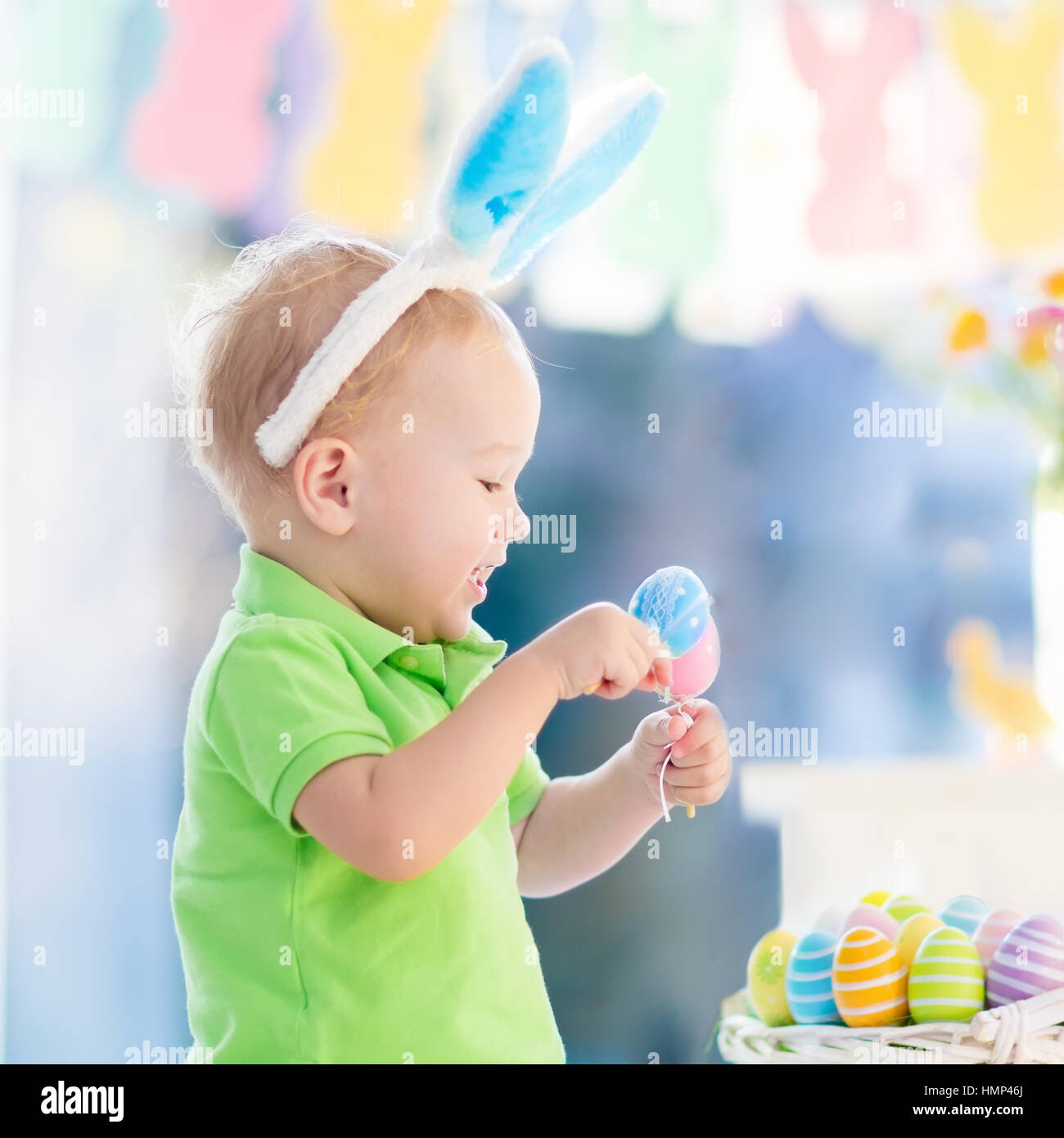 Kids celebrate Easter. Funny happy baby in bunny ears playing with ...