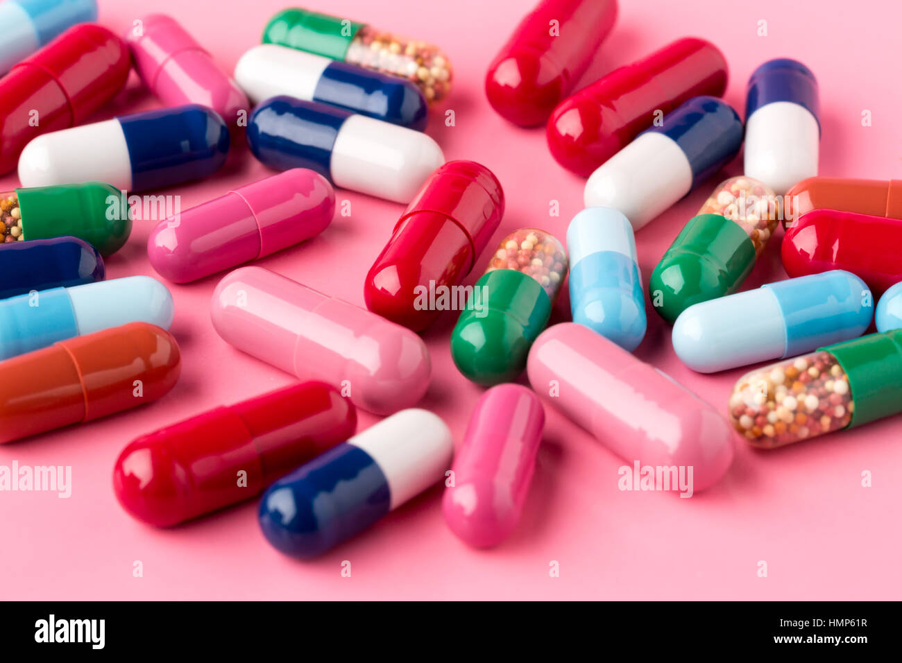 Colorful different medicine capsules on pink background Stock Photo - Alamy