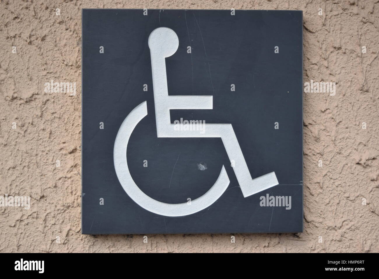 Grey tile disabled sign on a wall Stock Photo - Alamy