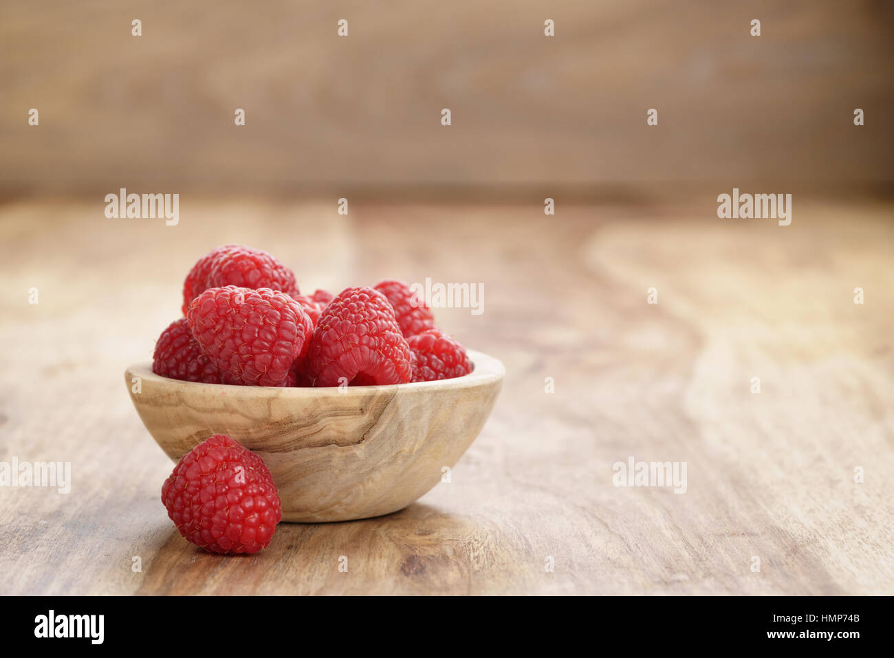 wood bowl full of ripe raspberries on old wooden table Stock Photo - Alamy