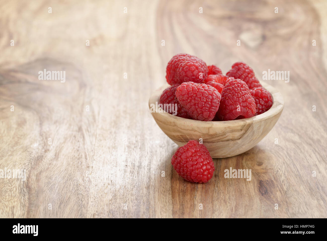 wood bowl full of ripe raspberries on old wooden table Stock Photo - Alamy