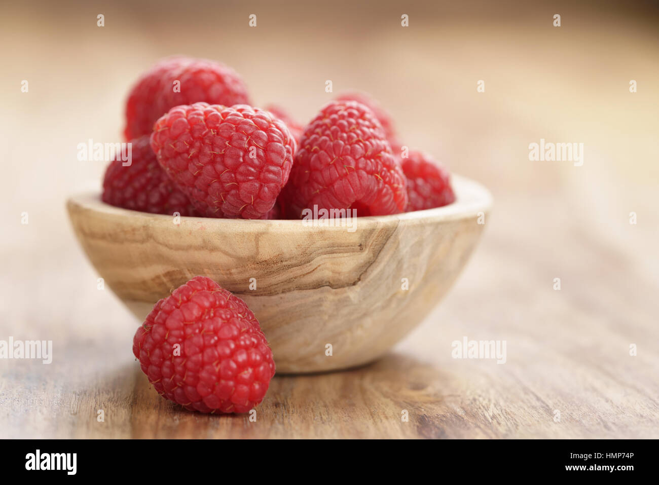 wood bowl full of ripe raspberries on old wooden table Stock Photo - Alamy