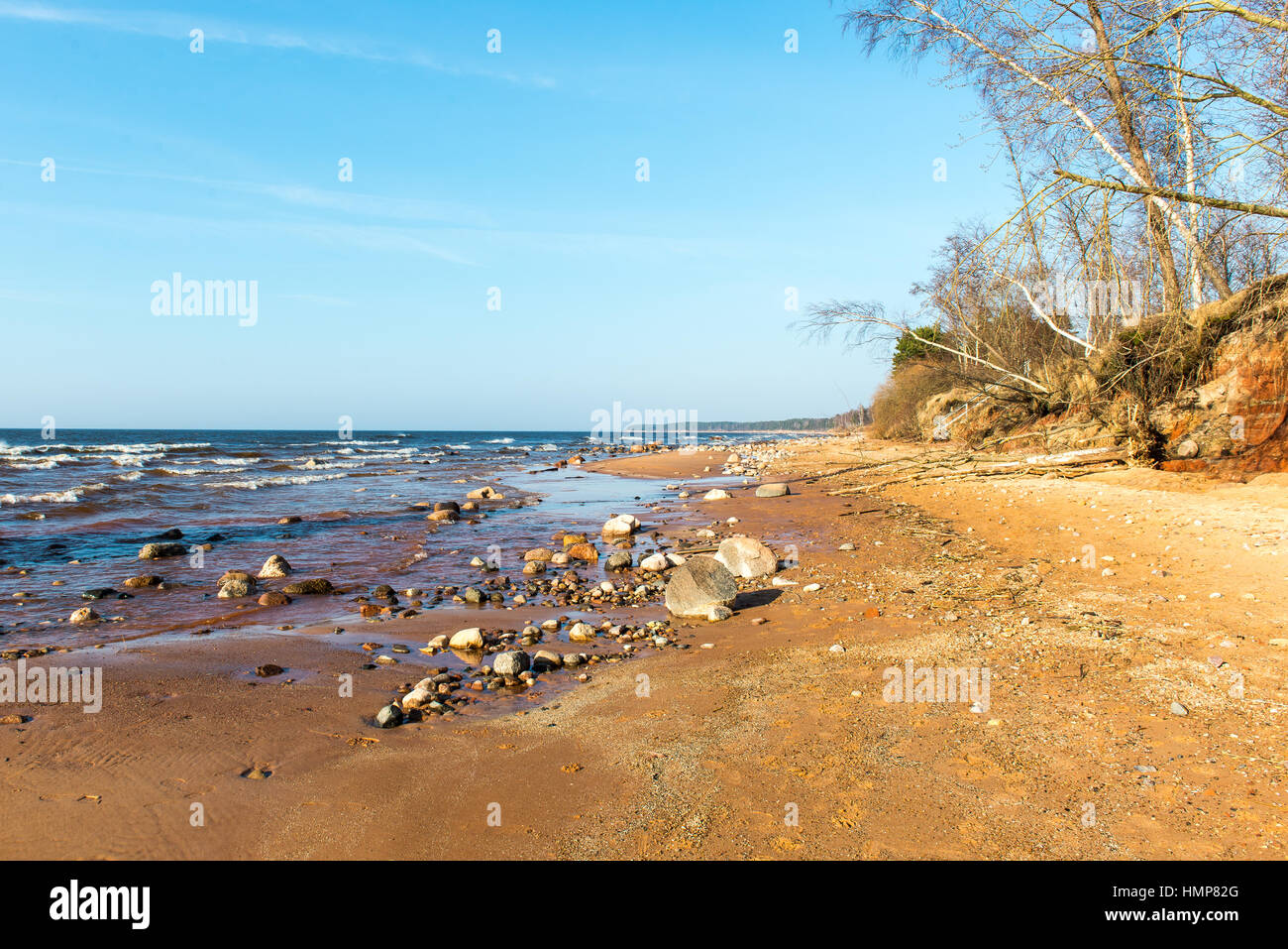 Shoreline of Baltic sea beach with rocks and sand dunes under clouds ...