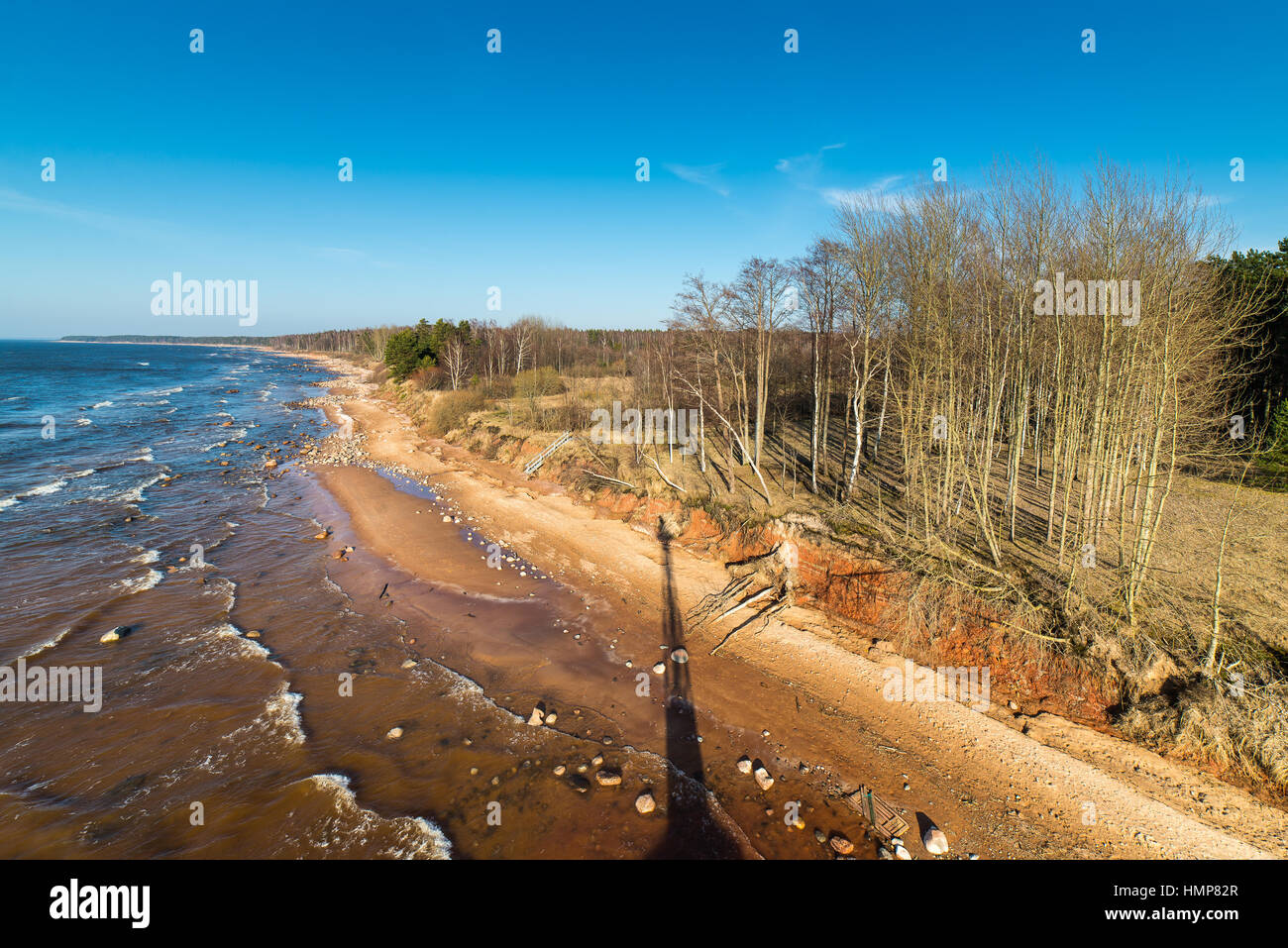 Shoreline of Baltic sea beach with rocks and sand dunes under clouds ...