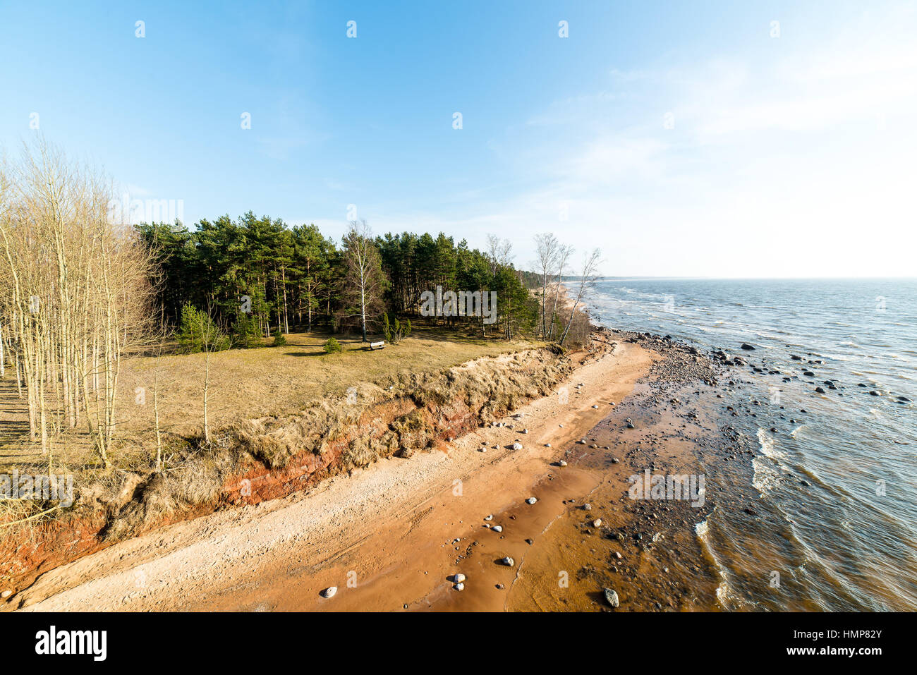 Shoreline of Baltic sea beach with rocks and sand dunes under clouds ...