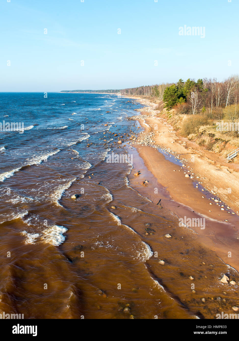 Shoreline of Baltic sea beach with rocks and sand dunes under clouds ...
