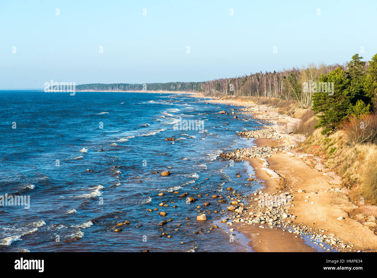 Shoreline of Baltic sea beach with rocks and sand dunes under clouds ...