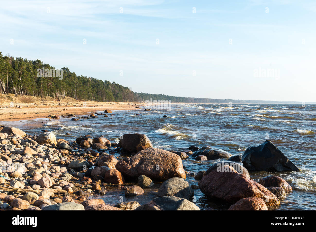 Shoreline of Baltic sea beach with rocks and sand dunes under clouds ...