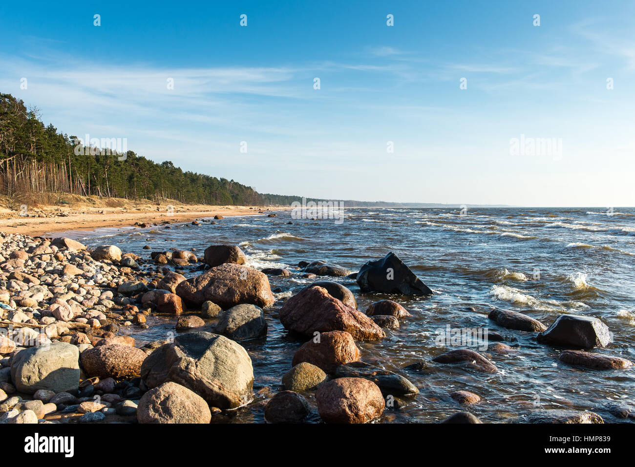 Shoreline of Baltic sea beach with rocks and sand dunes under clouds ...