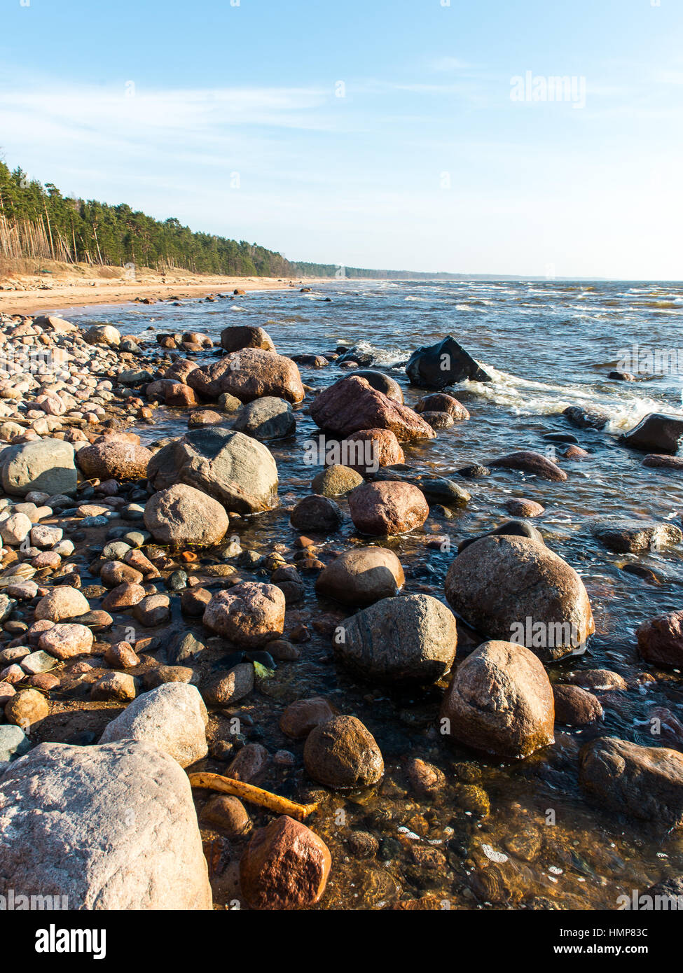 Shoreline of Baltic sea beach with rocks and sand dunes under clouds ...