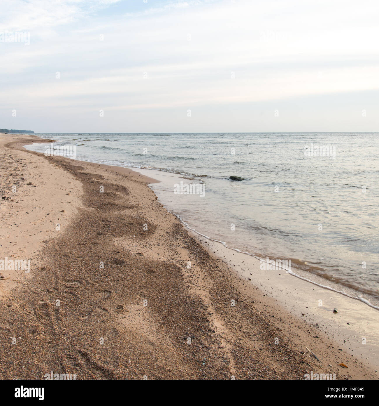 Shoreline of Baltic sea beach with rocks and sand dunes under clouds ...